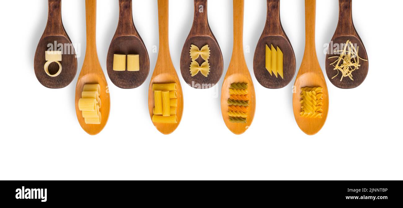 Wooden cooking spoons filled with various types dry pasta isolated on a ...