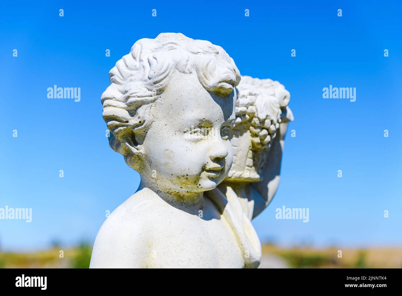 Closeup of a ancient young boy statue at summer park.Close-up Stock ...