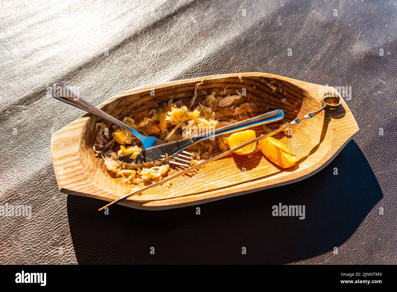 Leftover on a wooden plate.They lie on the table outdoors.Closeup Stock ...