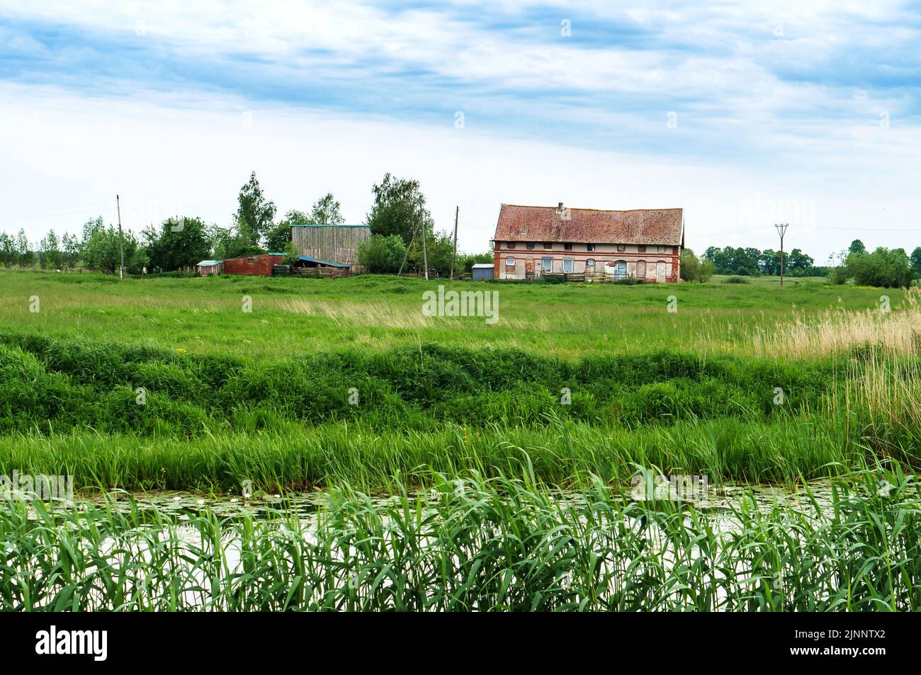 An old house in a field. A farm in the distance. The farm and the old ...