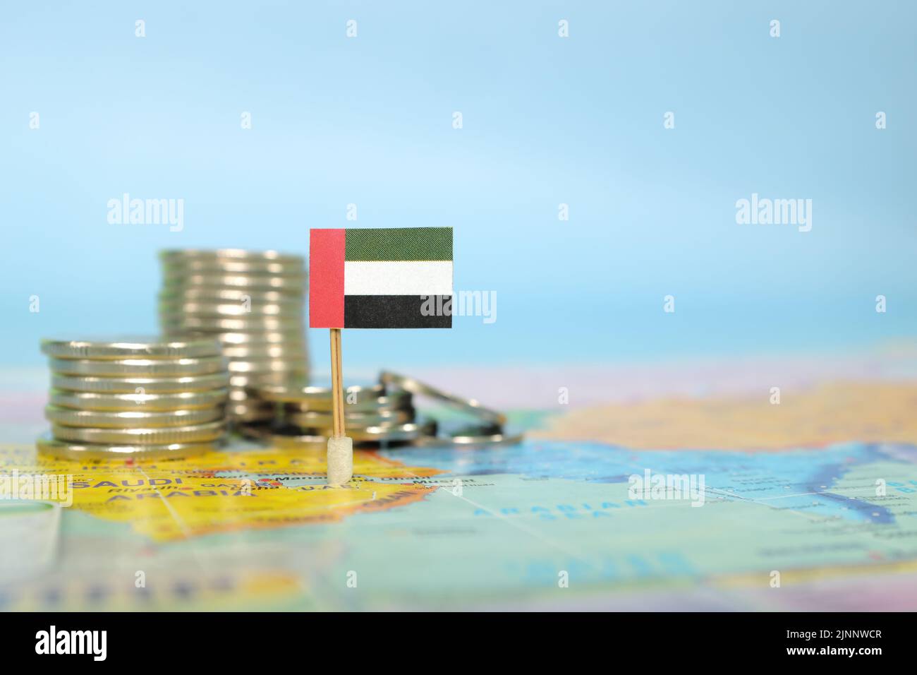Selective focus of UAE flag in blurry world map with coins. UAE economy ...