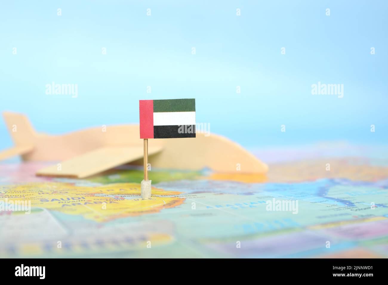 Selective focus of UAE flag in blurry world map and wooden airplane ...