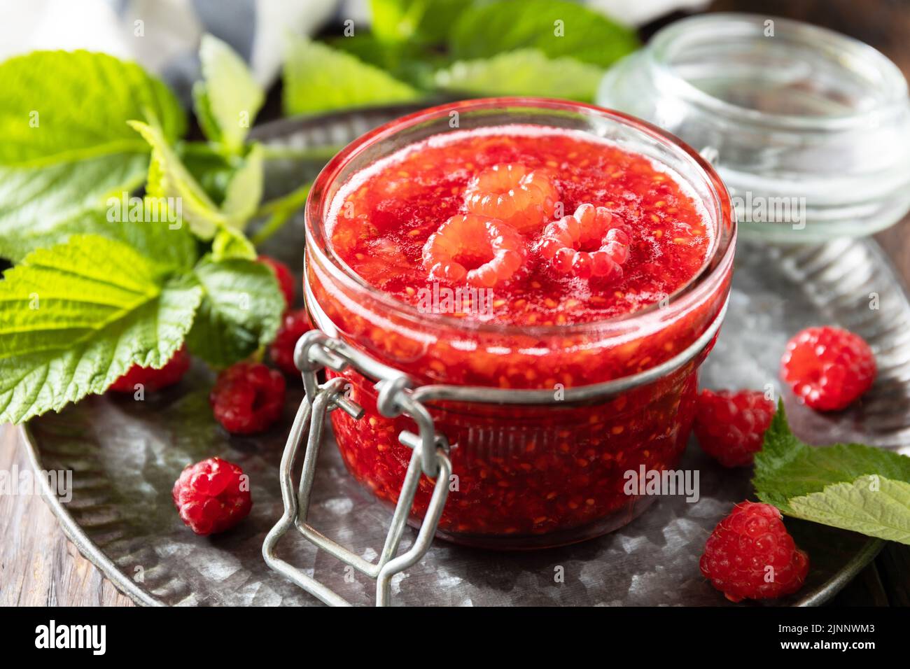 Homemade preservation. Delicious raspberries jam or jelly on a rustic ...