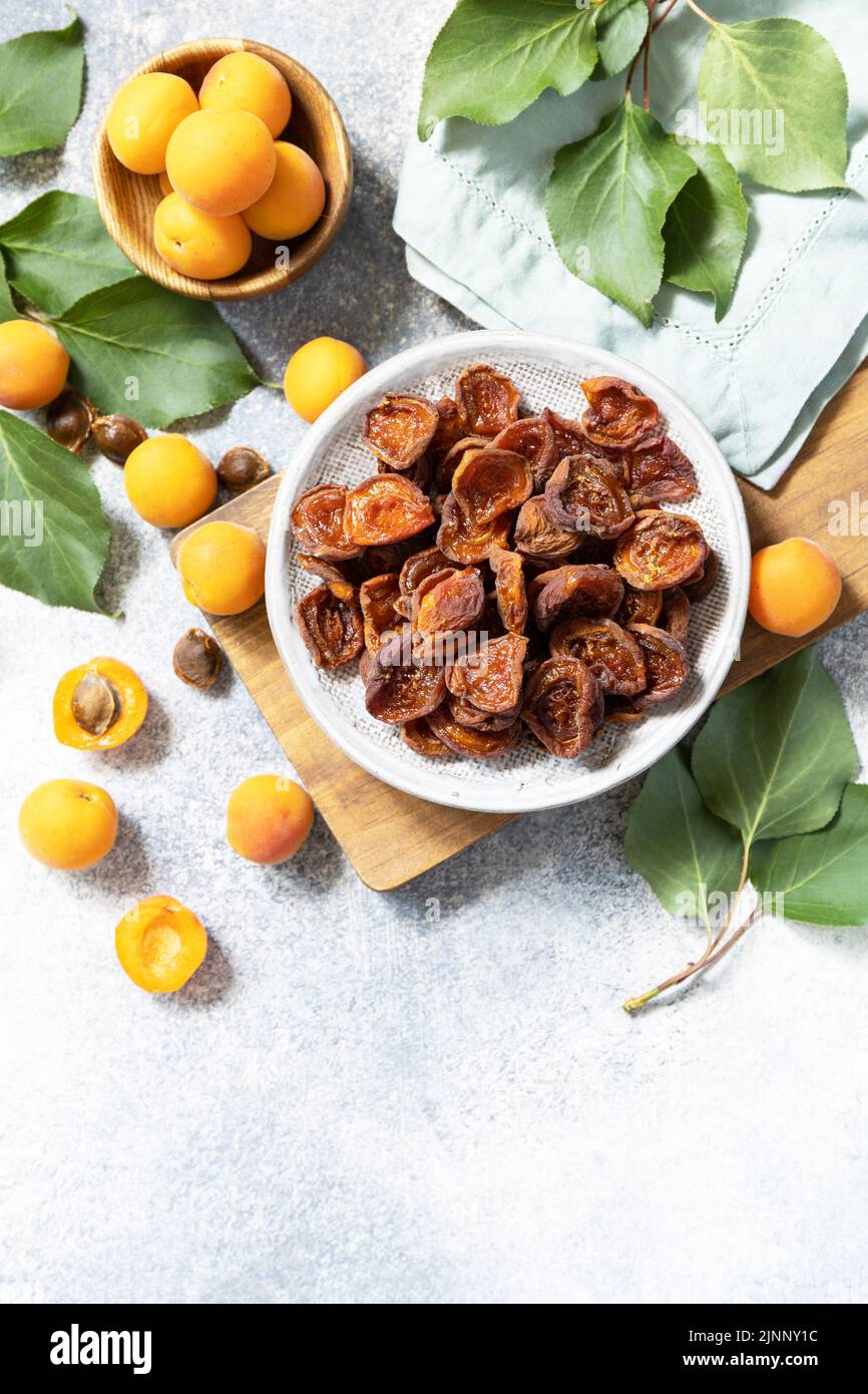 Dried fruits or candied fruit. Dried apricots and raw apricots on a ...
