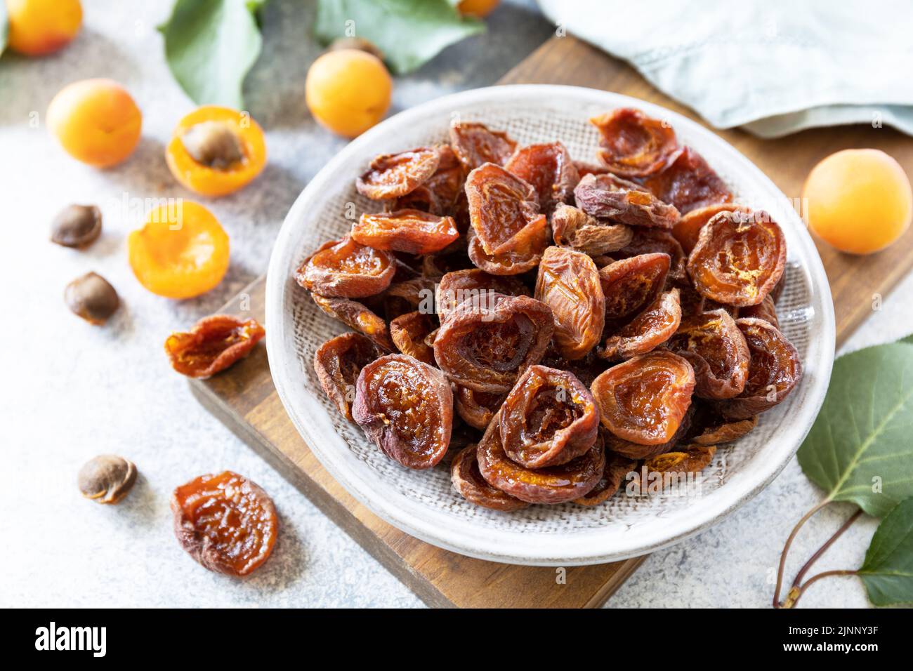 Dried fruits. Dried apricots and raw apricots on a gray stone ...