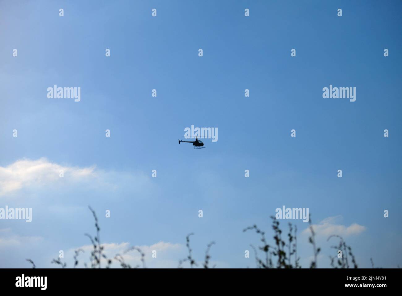 Helicopter with bright blue sky with few clouds background with ...