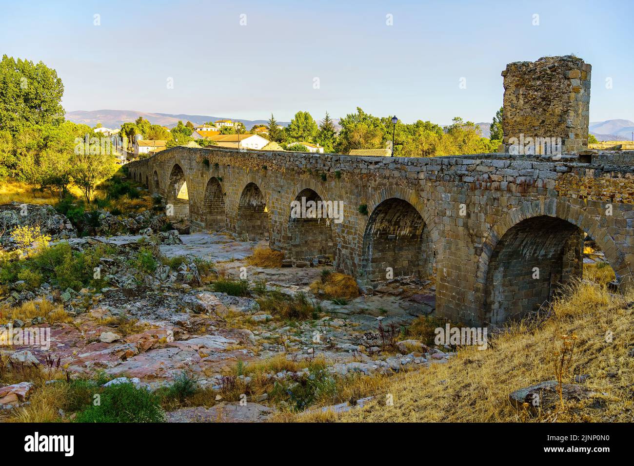 Medieval stone bridge that crosses the dry river in a summer season ...