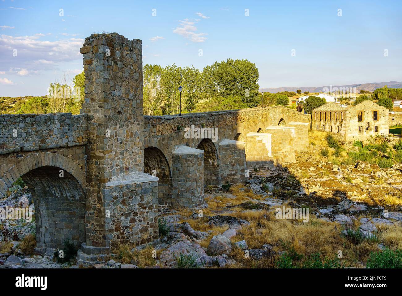 Medieval stone bridge that crosses the dry river in a summer season ...