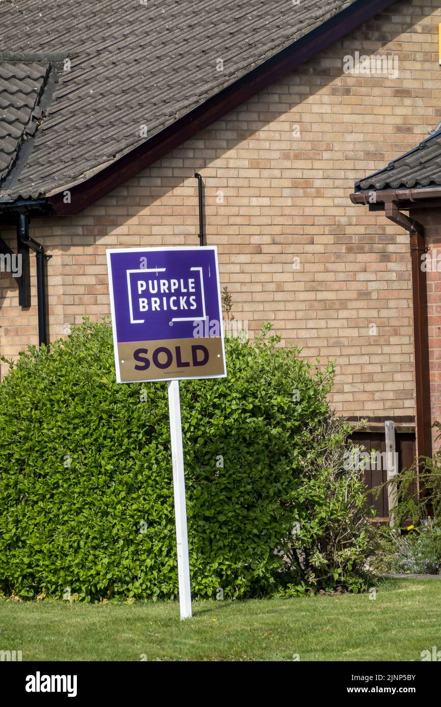 Purple bricks estate agency sign Stock Photo - Alamy