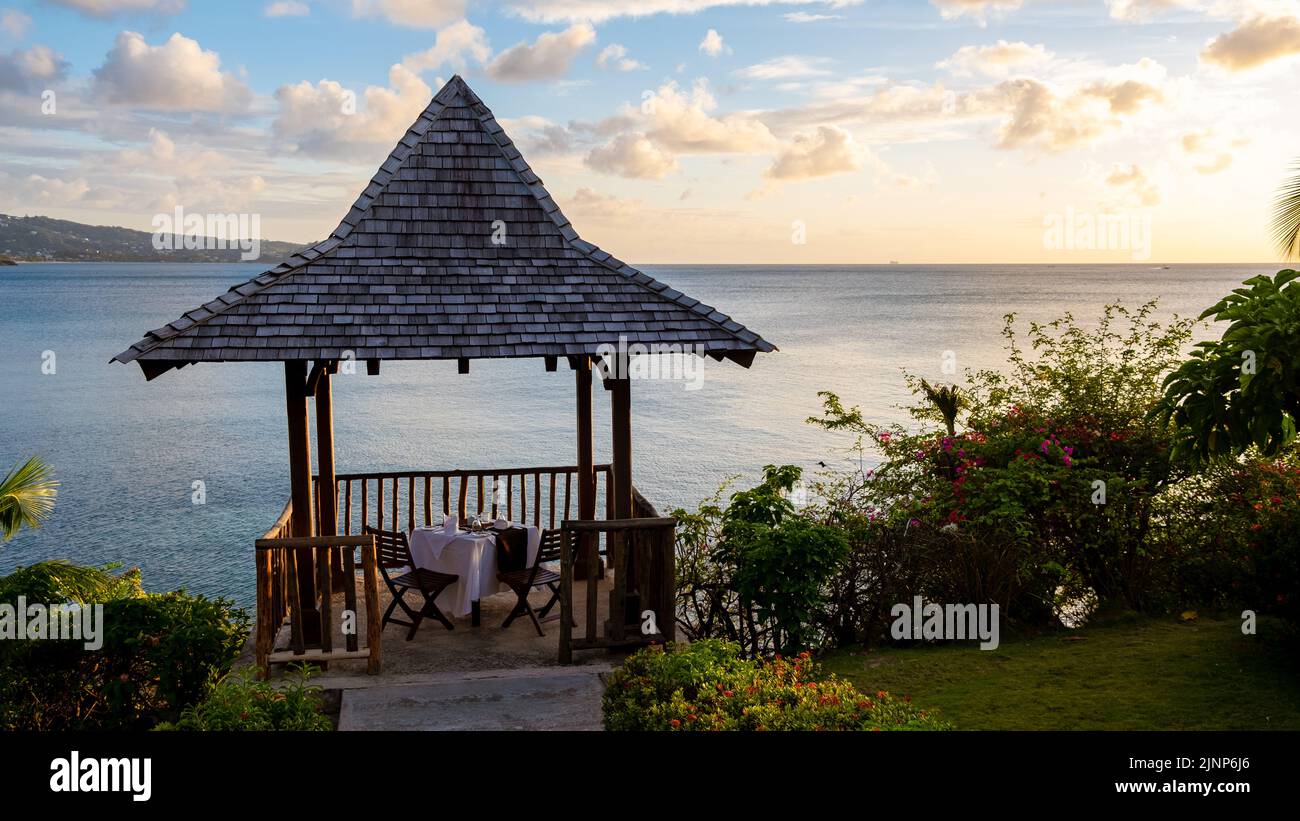 dinner table during sunset, romantic dinner by the ocean watching the ...