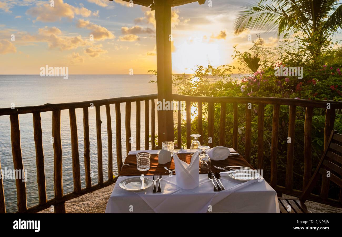 dinner table during sunset, romantic dinner by the ocean watching the ...