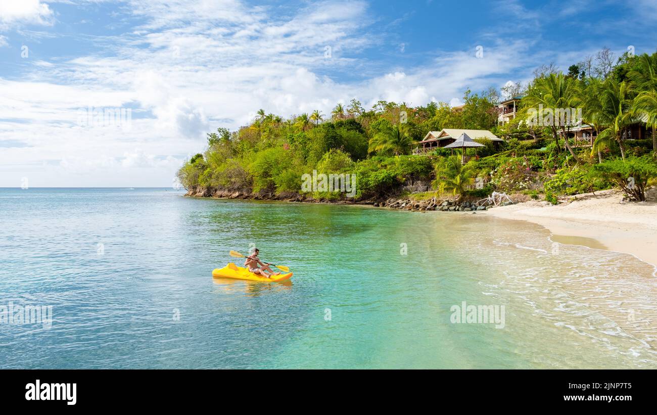 young men in a kayak at a tropical island in the Caribbean sea, St ...