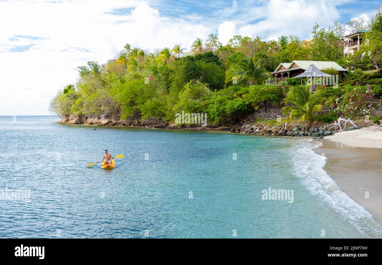 young men in a kayak at a tropical island in the Caribbean sea, St ...