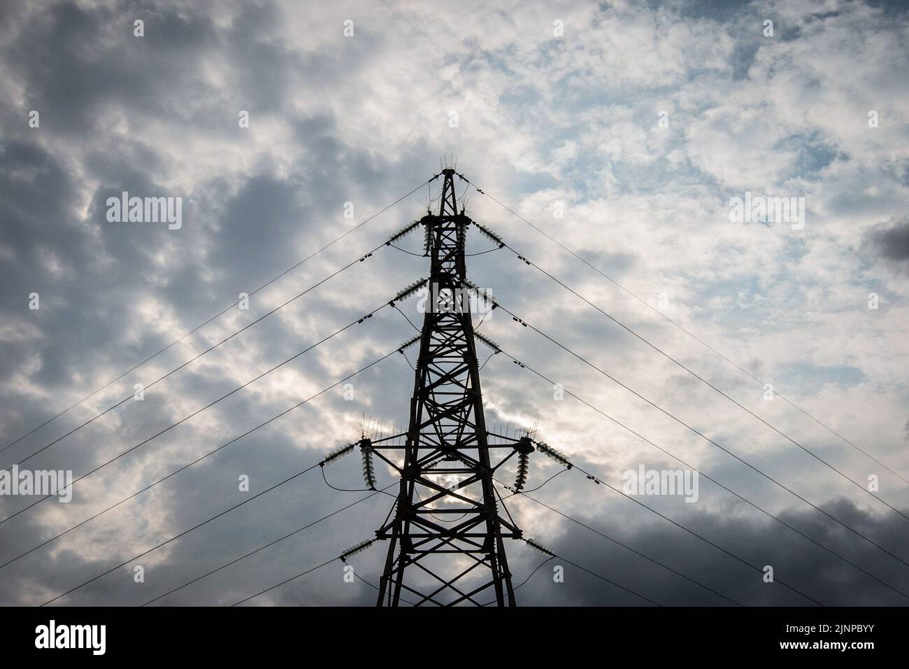 High voltage line pylons in a field near town of Bucha in Ukraine. Due ...