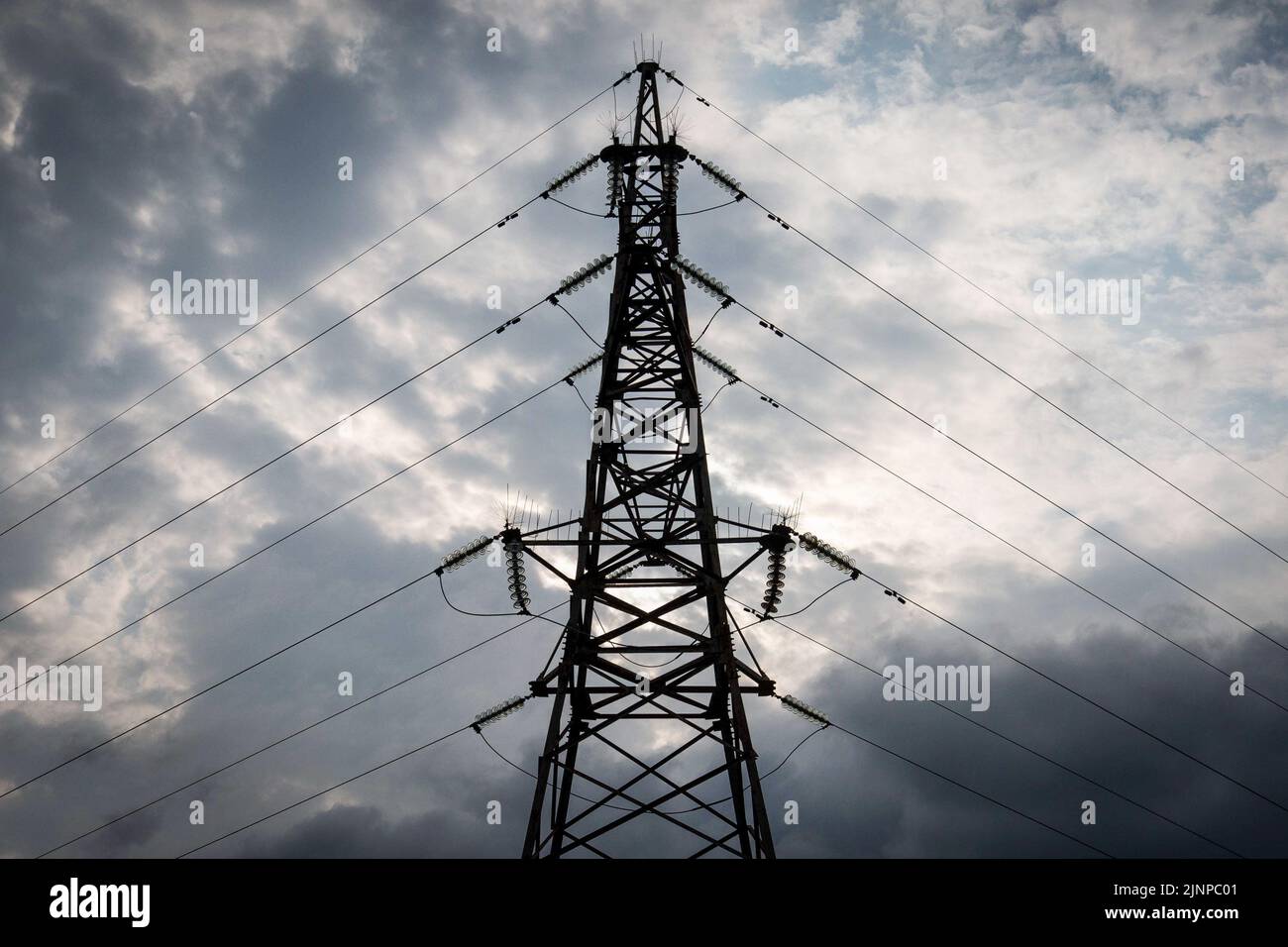 High voltage line pylons in a field near town of Bucha in Ukraine. Due ...