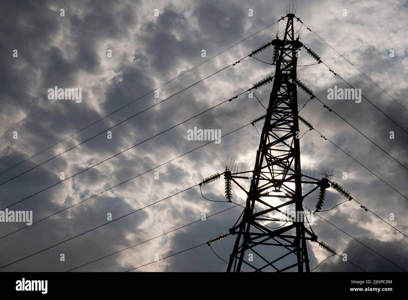 High voltage line pylons in a field near town of Bucha in Ukraine. Due ...