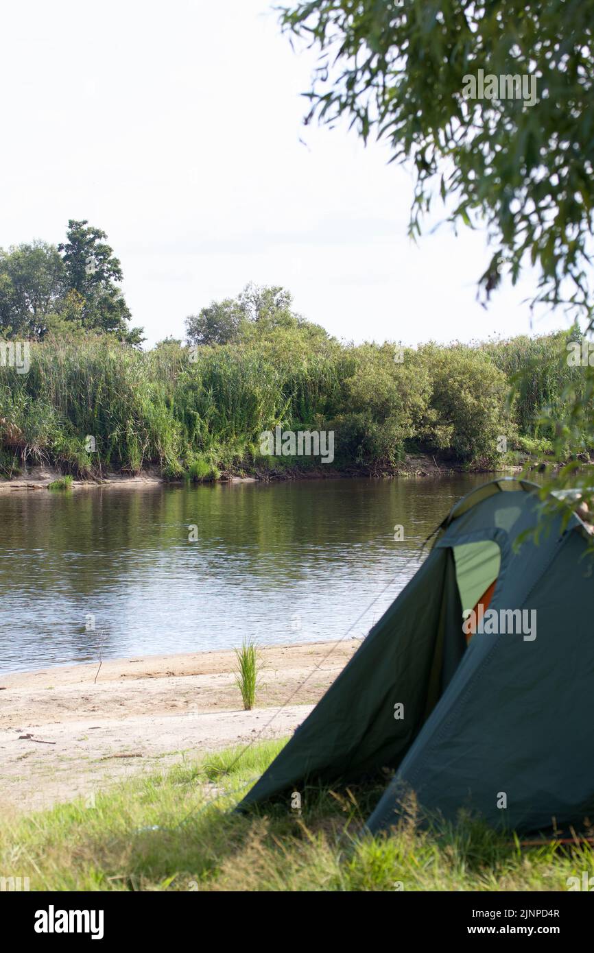 Tent camp on the river bank. A fragment of the tent is visible. Medium ...