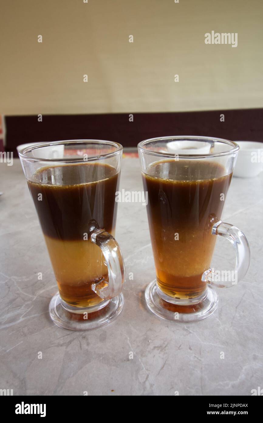 Coffee with syrup and cream. In glass mugs. The layers of the drink are ...
