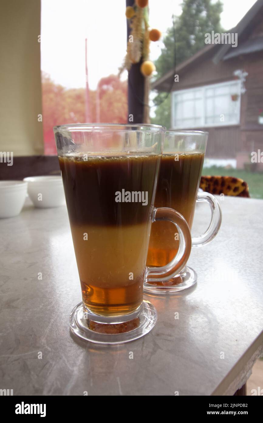 Coffee with syrup and cream. In glass mugs. The layers of the drink are ...