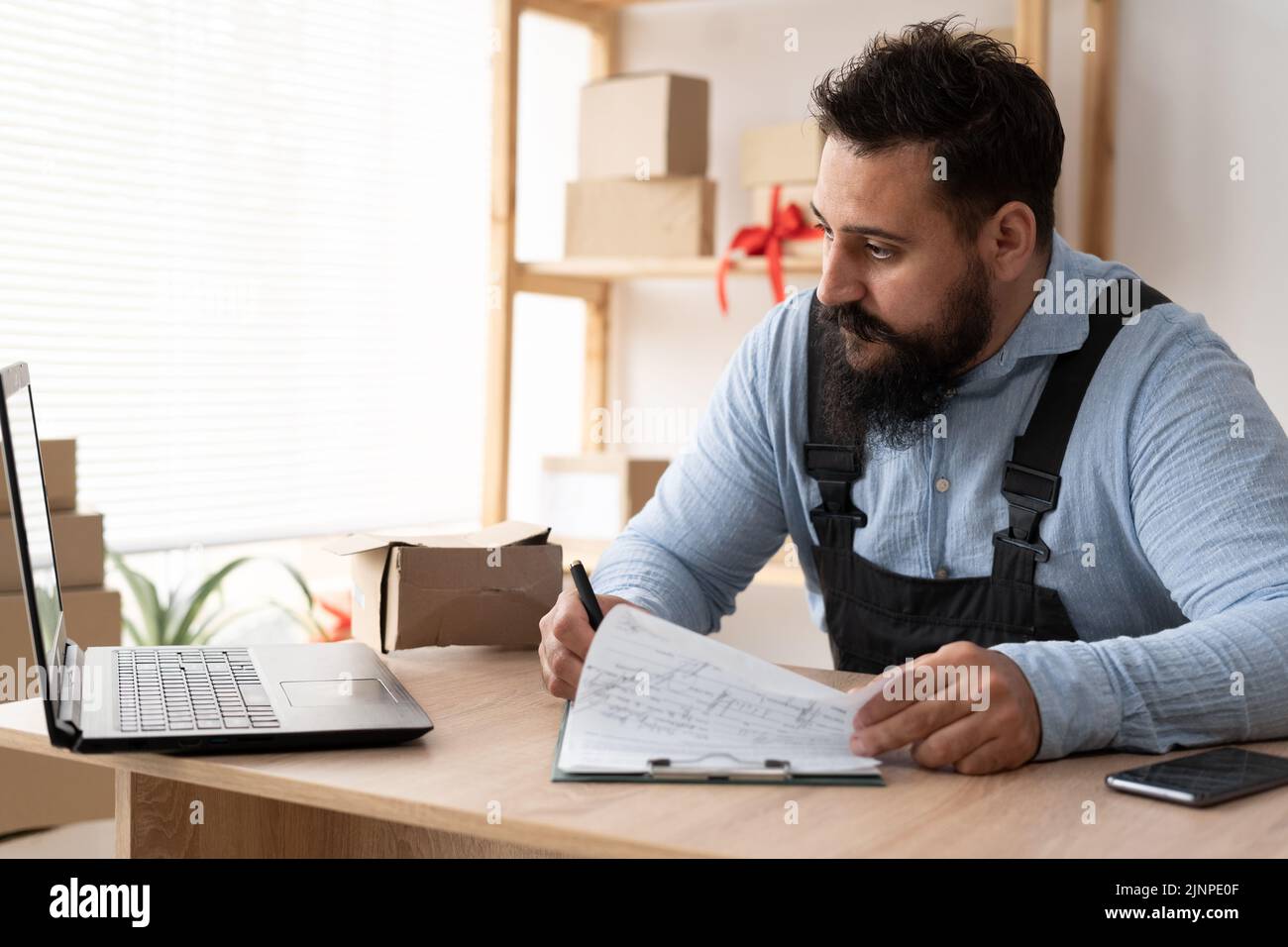 Indian male business owner sitting at home office using computer ...