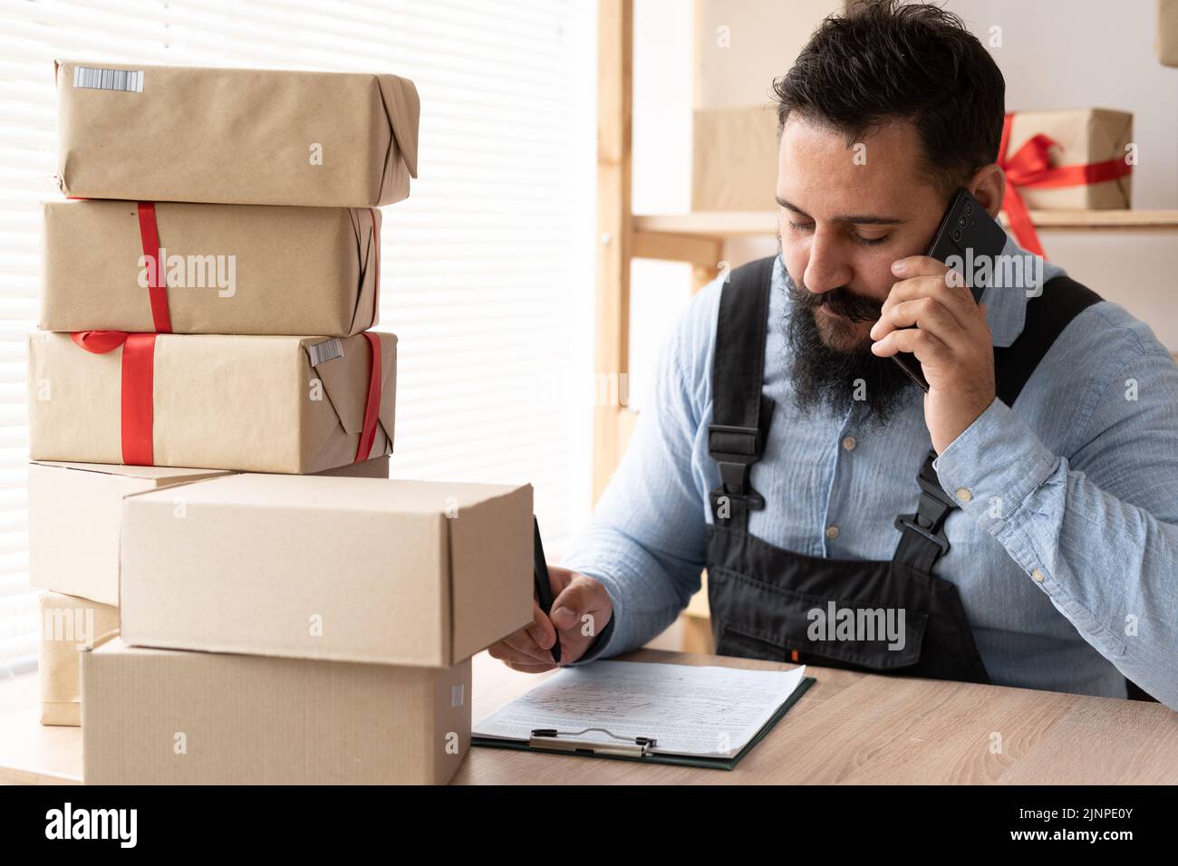 Indian man online seller confirming orders from customer on the phone ...