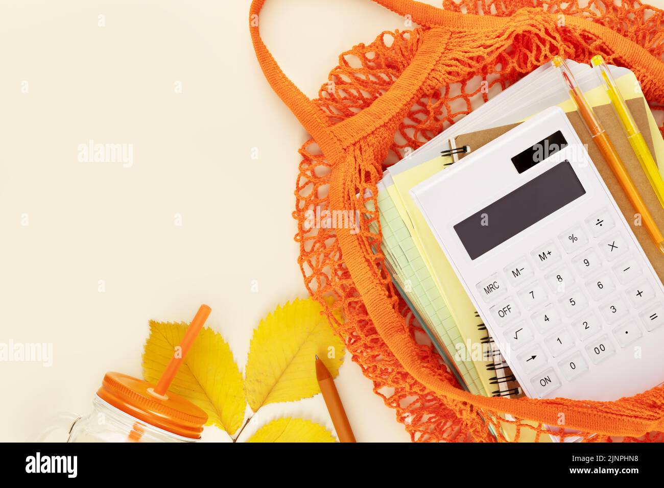 Autumn composition with school supplies and calculator in a orange ...
