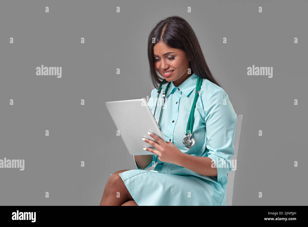 Young pretty doctor with stethoscope sitting on a chair Stock Photo - Alamy