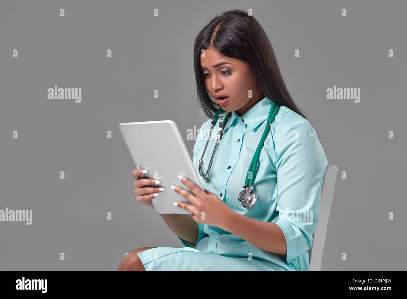 Young pretty doctor with stethoscope sitting on a chair Stock Photo - Alamy