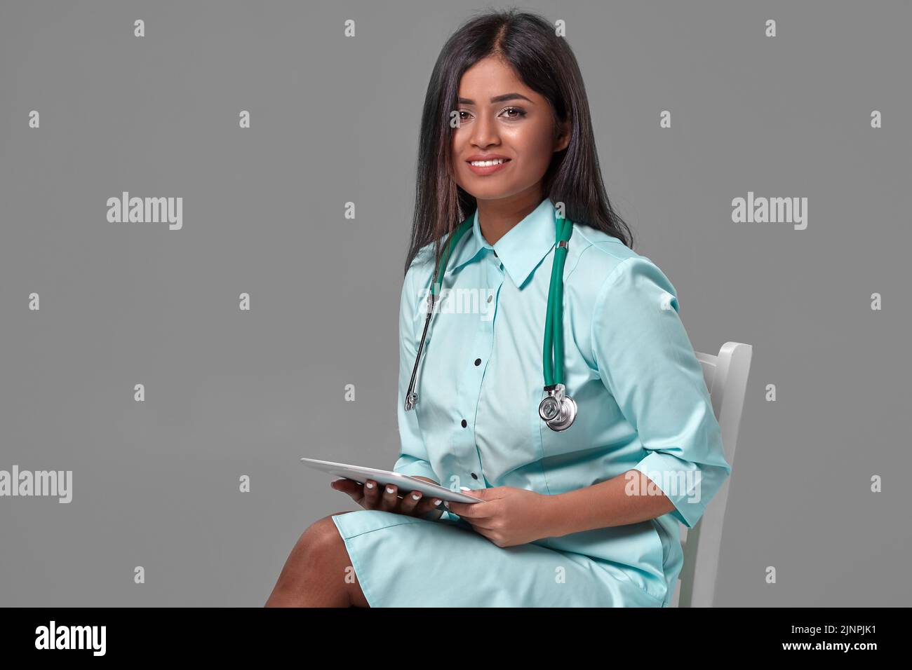 Young pretty doctor with stethoscope sitting on a chair Stock Photo - Alamy