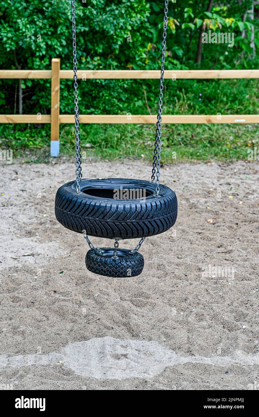 swing in chains at playingground with fence Stock Photo - Alamy