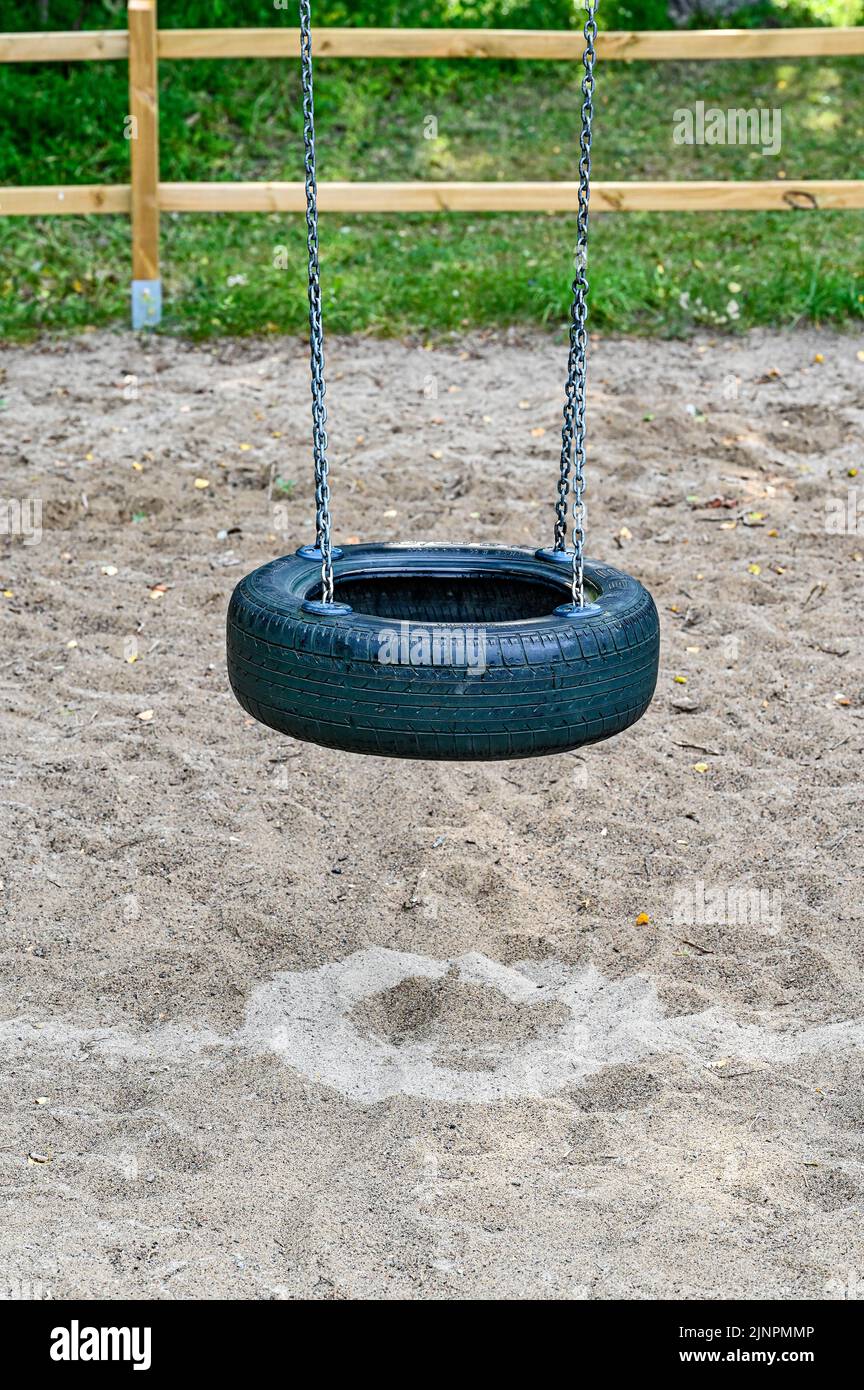 swing in chains at playingground with fence Stock Photo - Alamy
