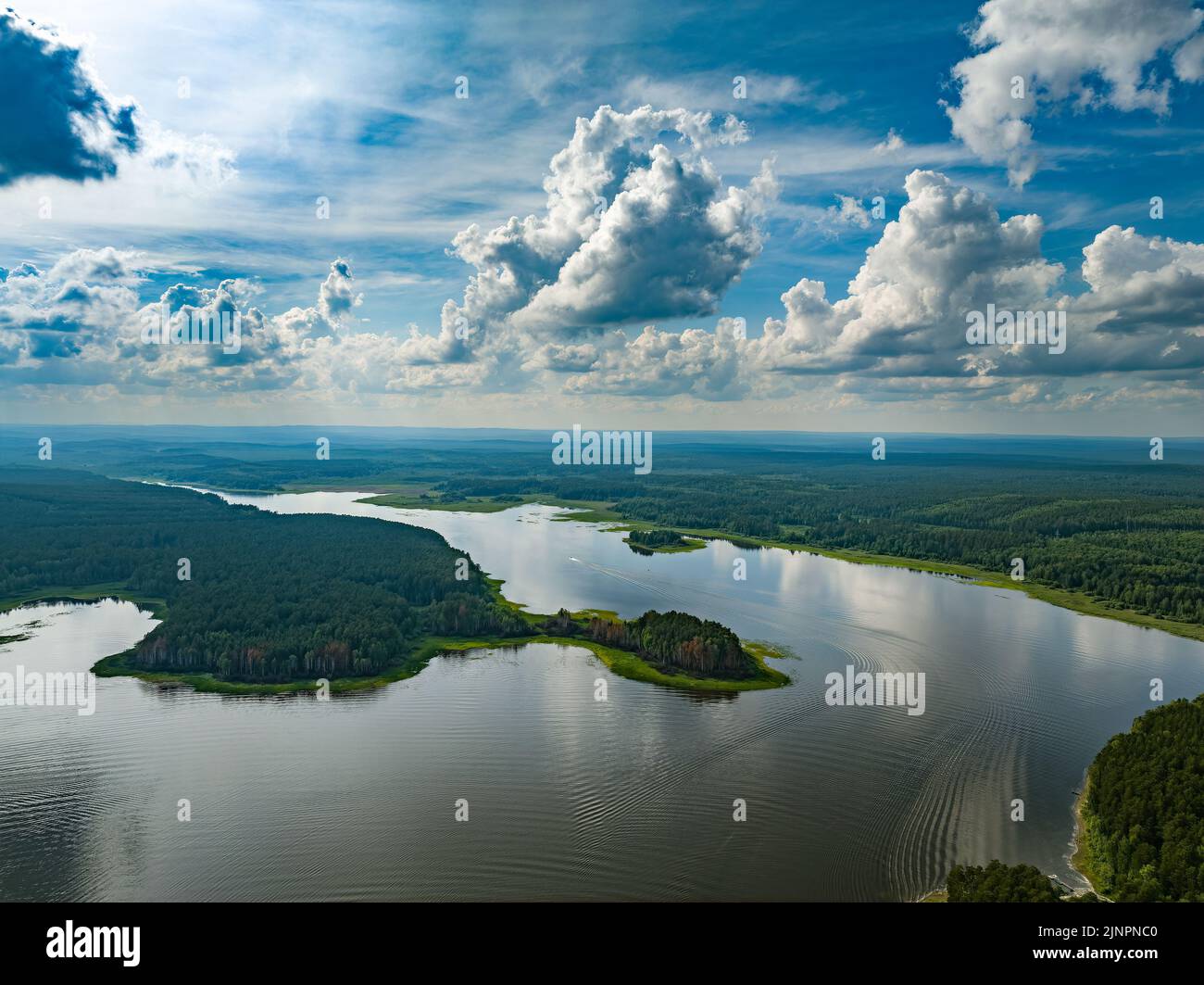 Big lake with green shores in bright sun light, aerial landscape ...