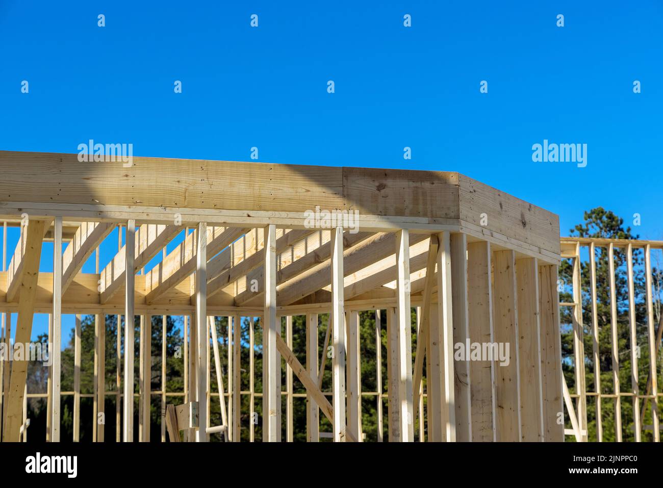 A new building with wooden trusses is being stick framework house with ...