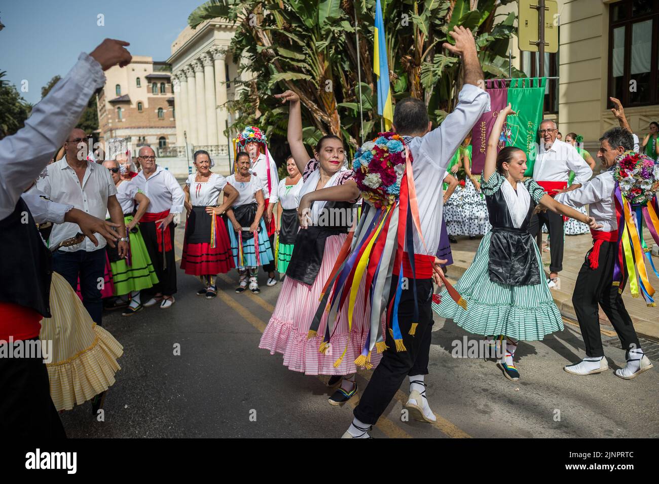 Women and men wearing flamenco and traditional clothes are seen dancing ...