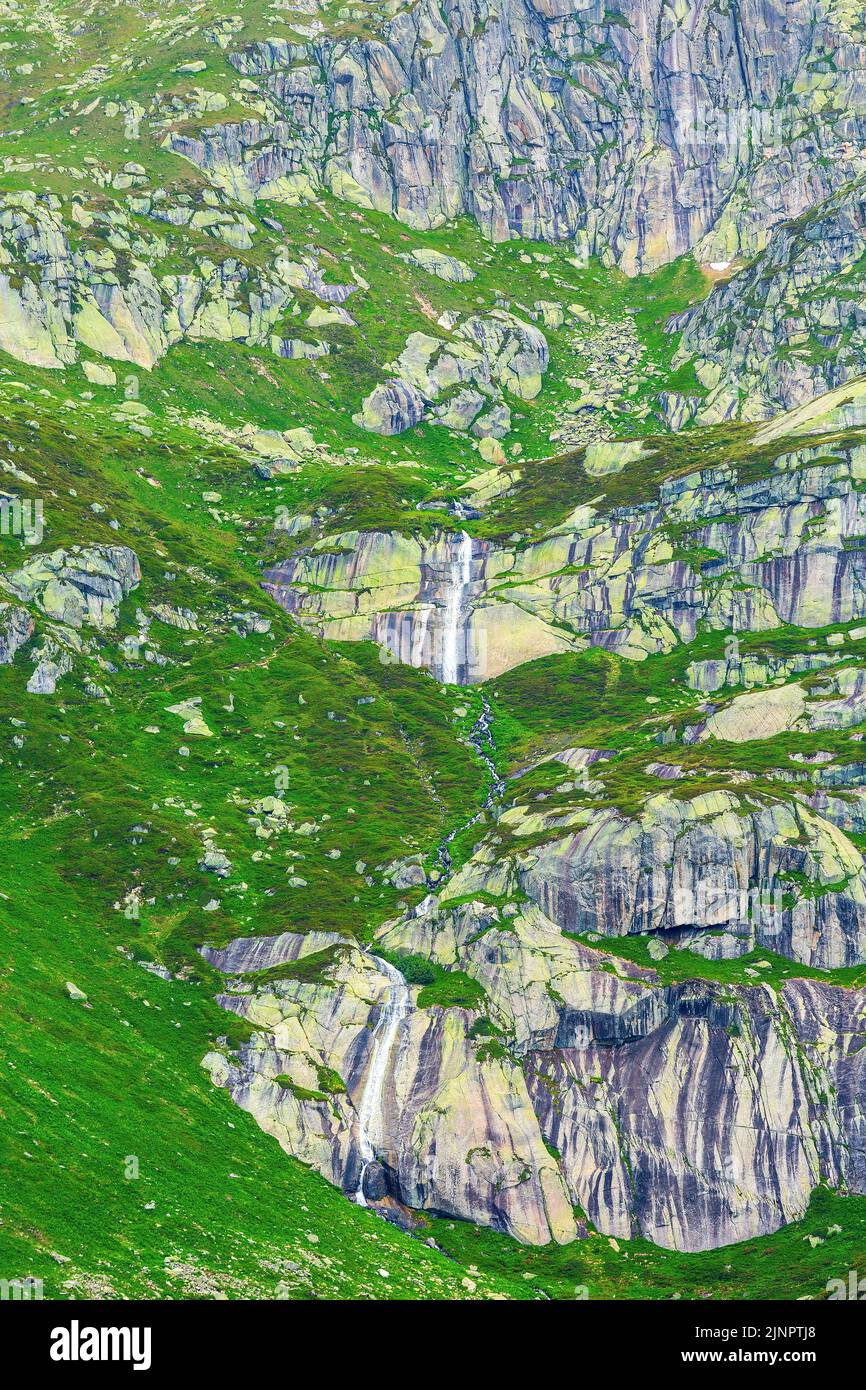 Natural waterfall high in the colorful mountains of Switzerland among ...