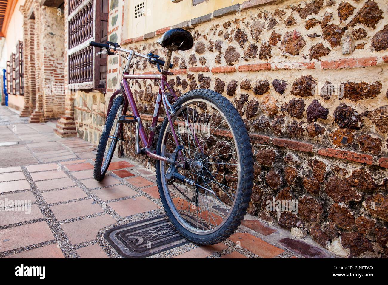 Bicycle parked next to an ancient stone wall at the colonial town of ...