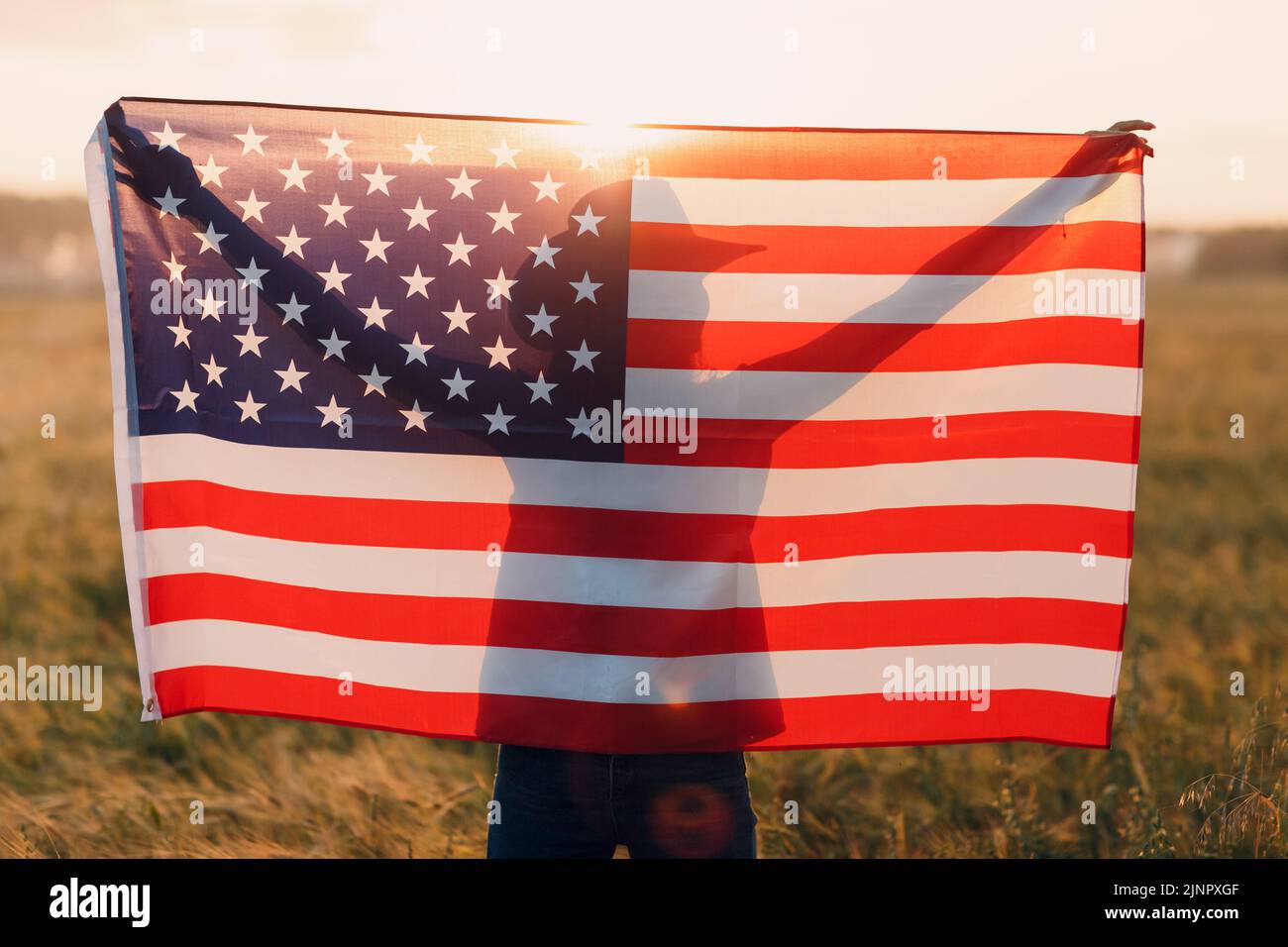 Woman silhouette in the agricultural field beyond the USA Flag on ...