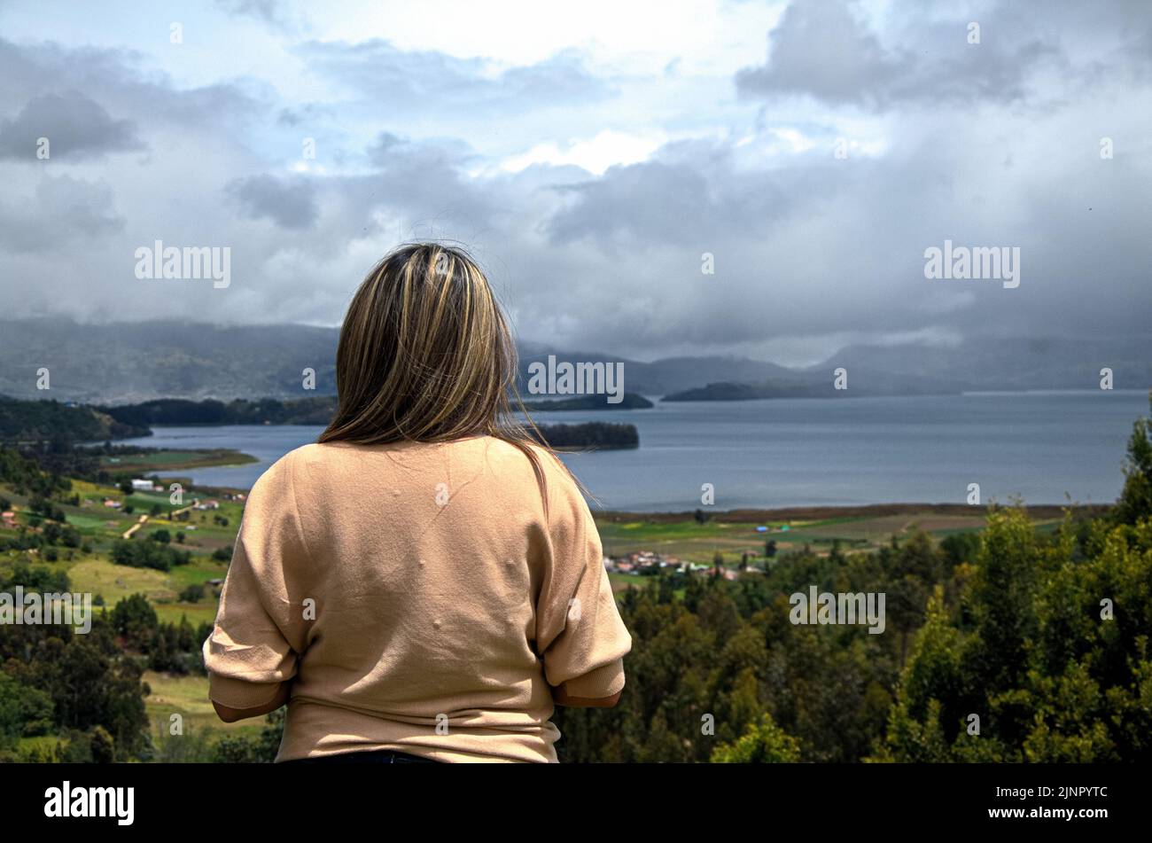 Woman observing a lake from a distance Stock Photo - Alamy
