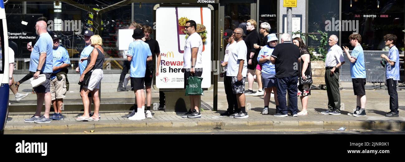 People, including Manchester City Football Club fans wearing a club ...