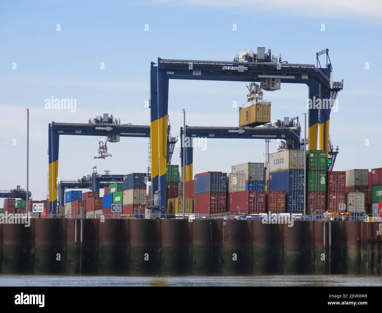 The large gantry cranes load and unload thousands of shipping ...