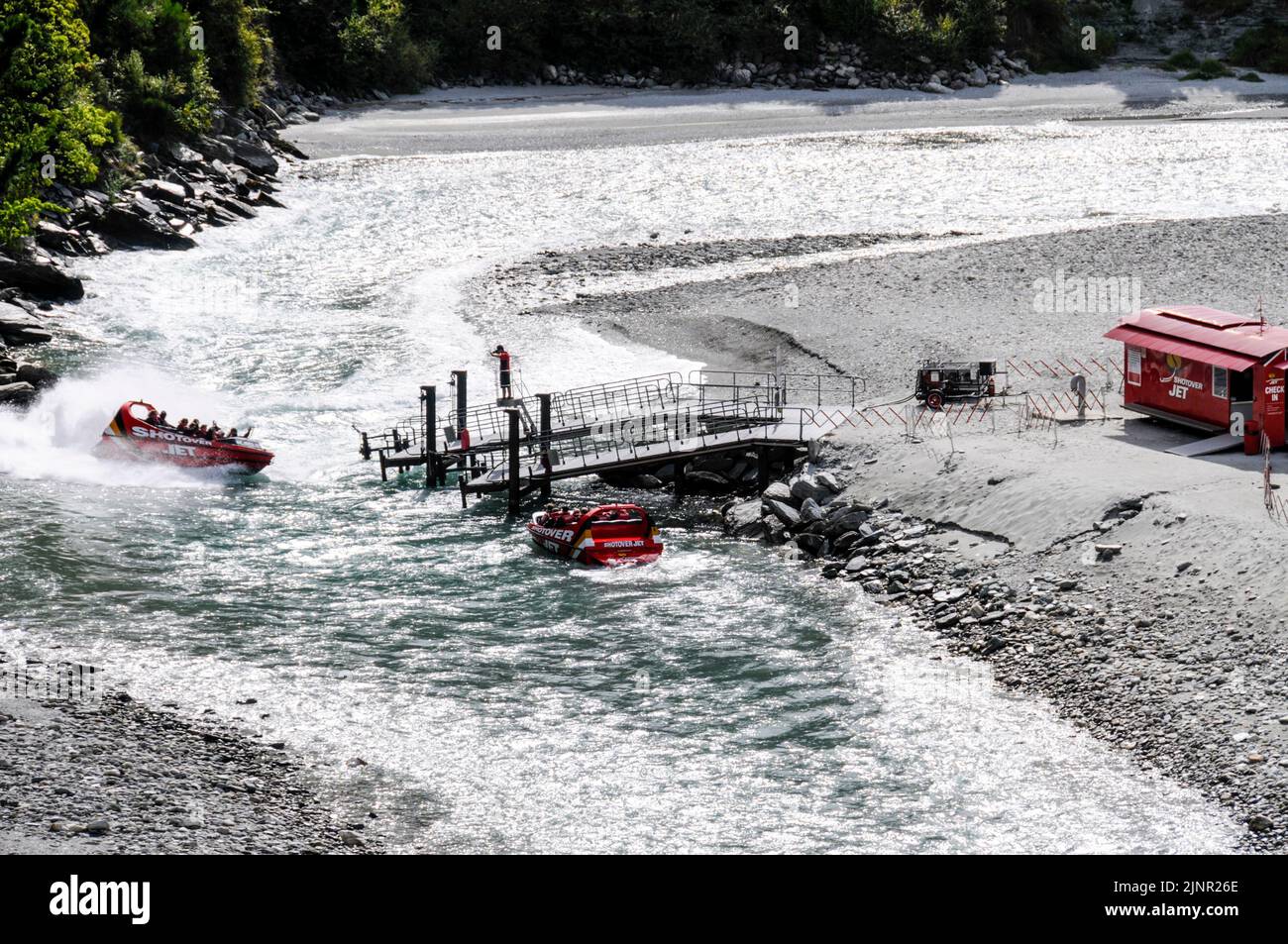 Visitors enjoy the high-speed thrills on a Shotover jet flat bottom ...