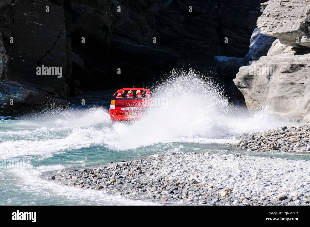 Visitors enjoy the high-speed thrills on a Shotover jet flat bottom ...