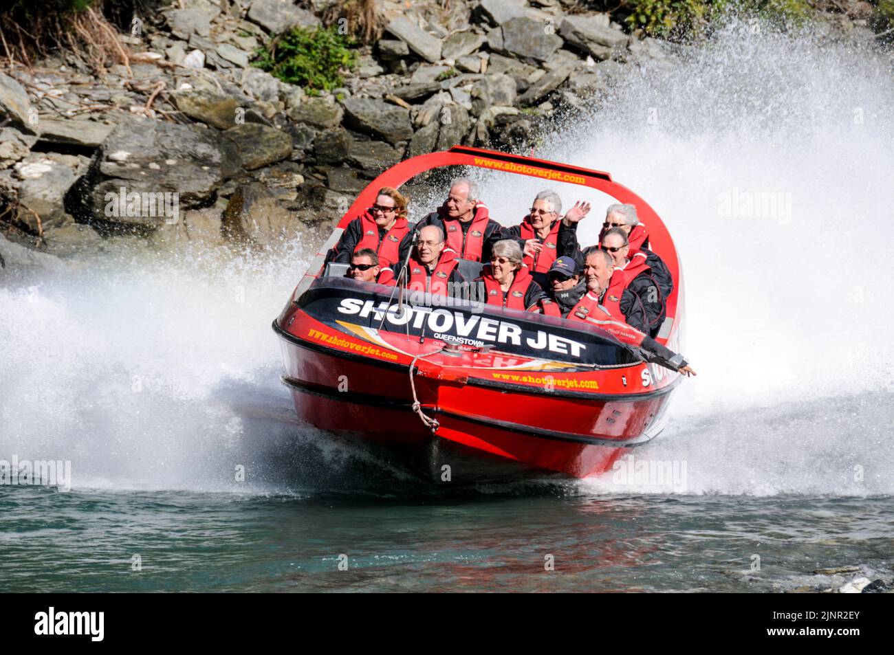 Visitors enjoy the high-speed thrills on a Shotover jet flat bottom ...