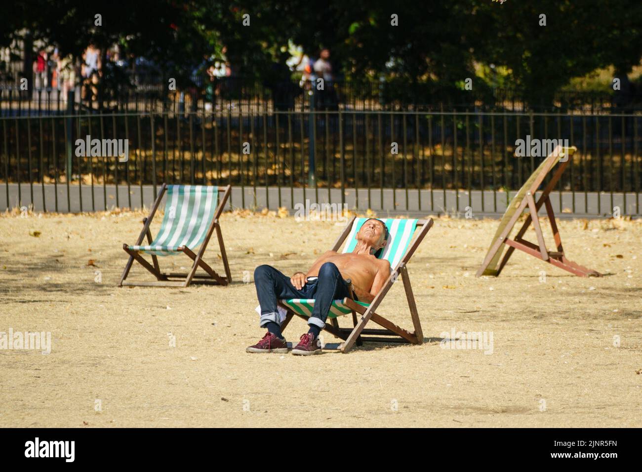A man sits in the sun in Hyde Park, London, as a drought has been ...