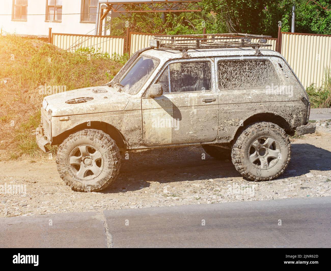 Car completely covered in dried mud is parked on the roadside in the ...