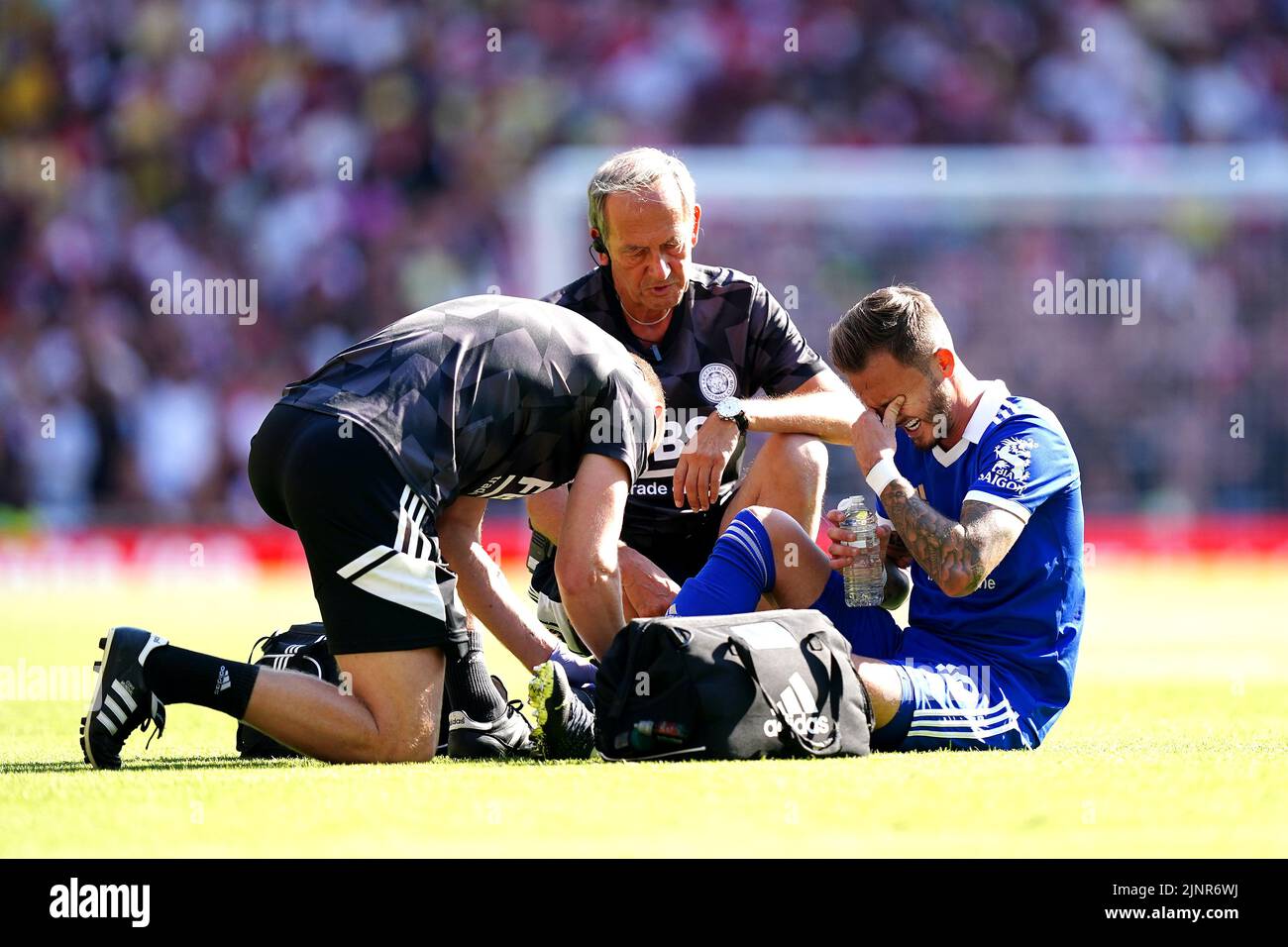 Leicester City's James Maddison (right) is treated for an injury during ...