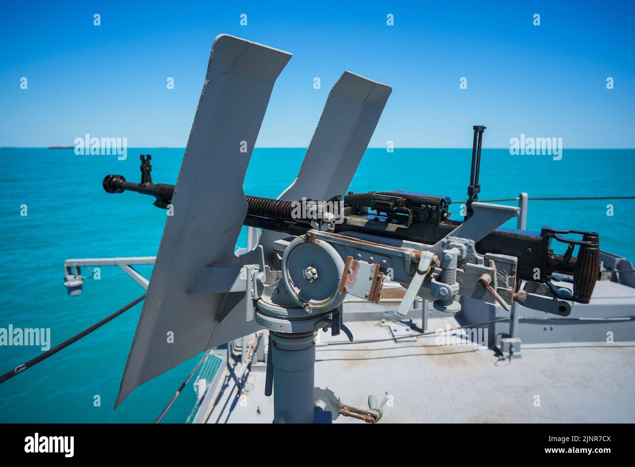 Color image of an automated machine gun on the deck of a military ship ...