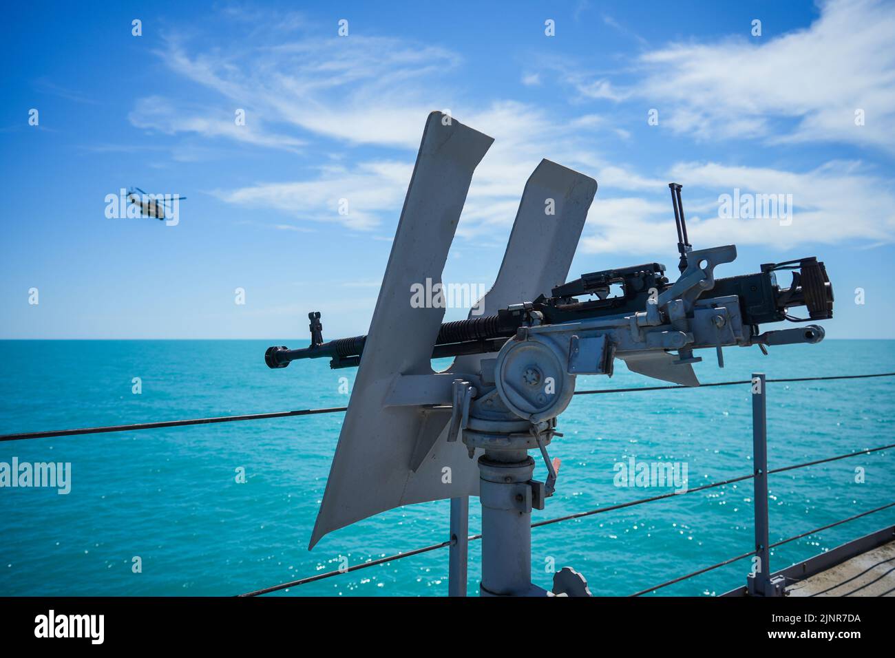 Color image of an automated machine gun on the deck of a military ship ...