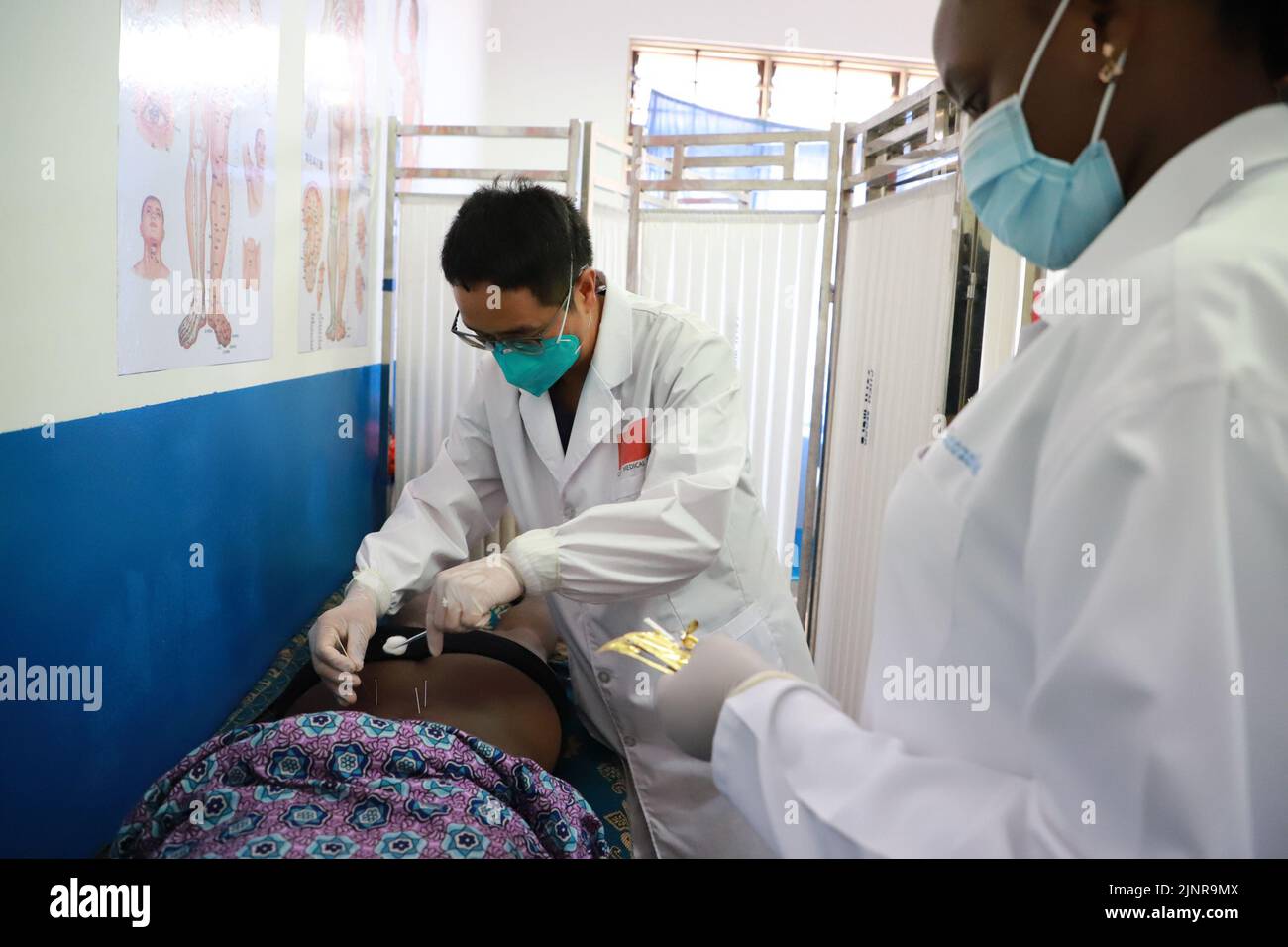 Kampala, Uganda. 10th Aug, 2022. Chinese doctor Li Xiaobin (L) gives a ...