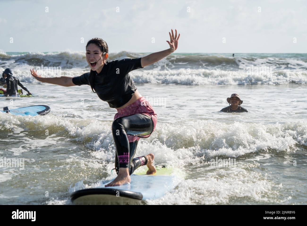 A surfing student successfully rides a wave in Khao Lak, the only place ...